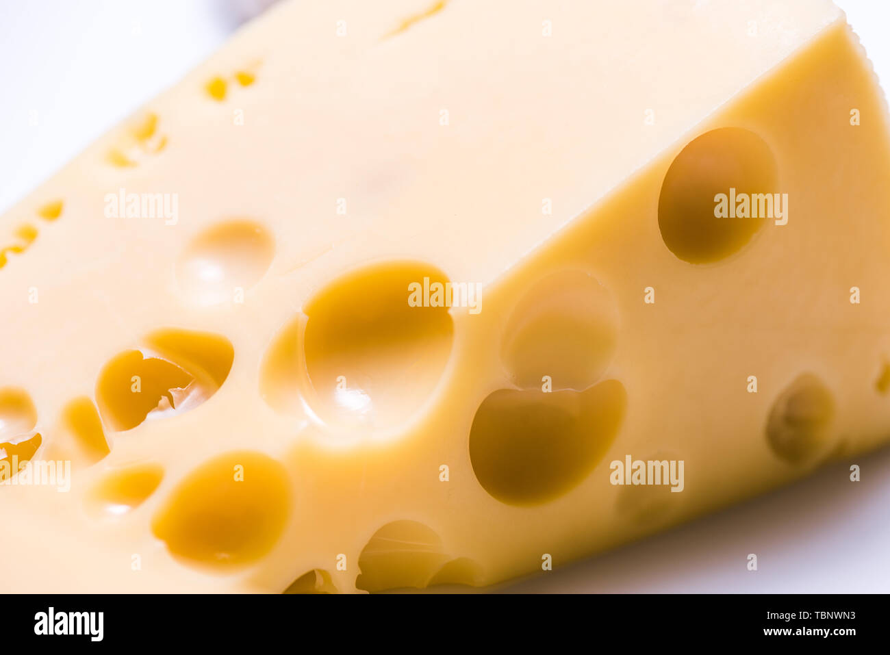 large piece of yellow cheese close-up on white background Stock Photo ...