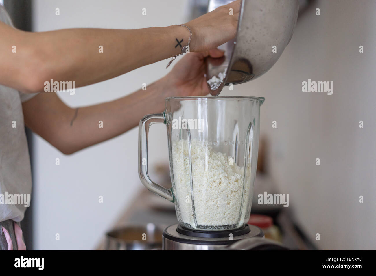 Woman pouring cottage cheese into a blender in the kitchen Stock Photo ...