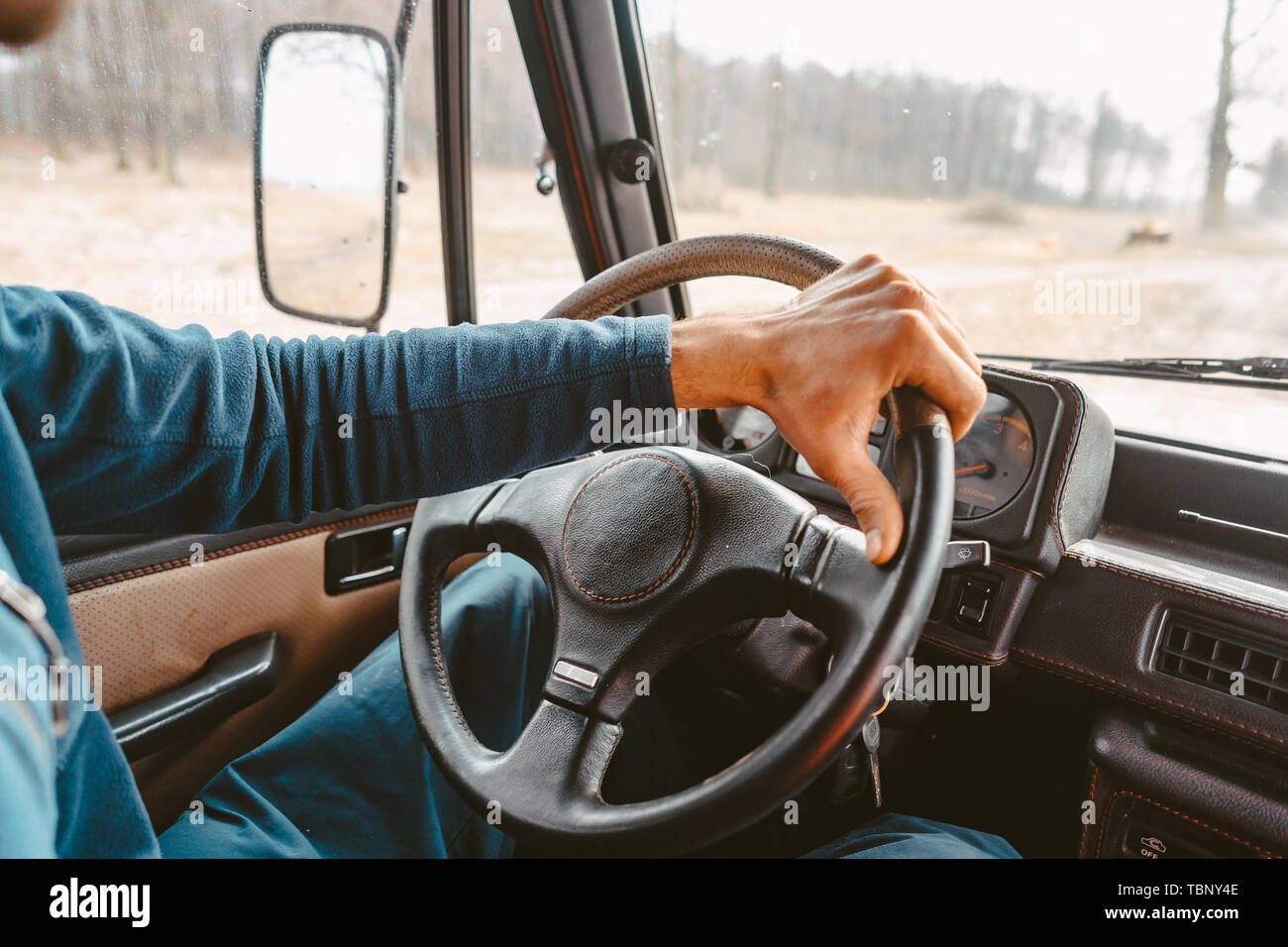 man driving suv car by forest trail road Stock Photo - Alamy