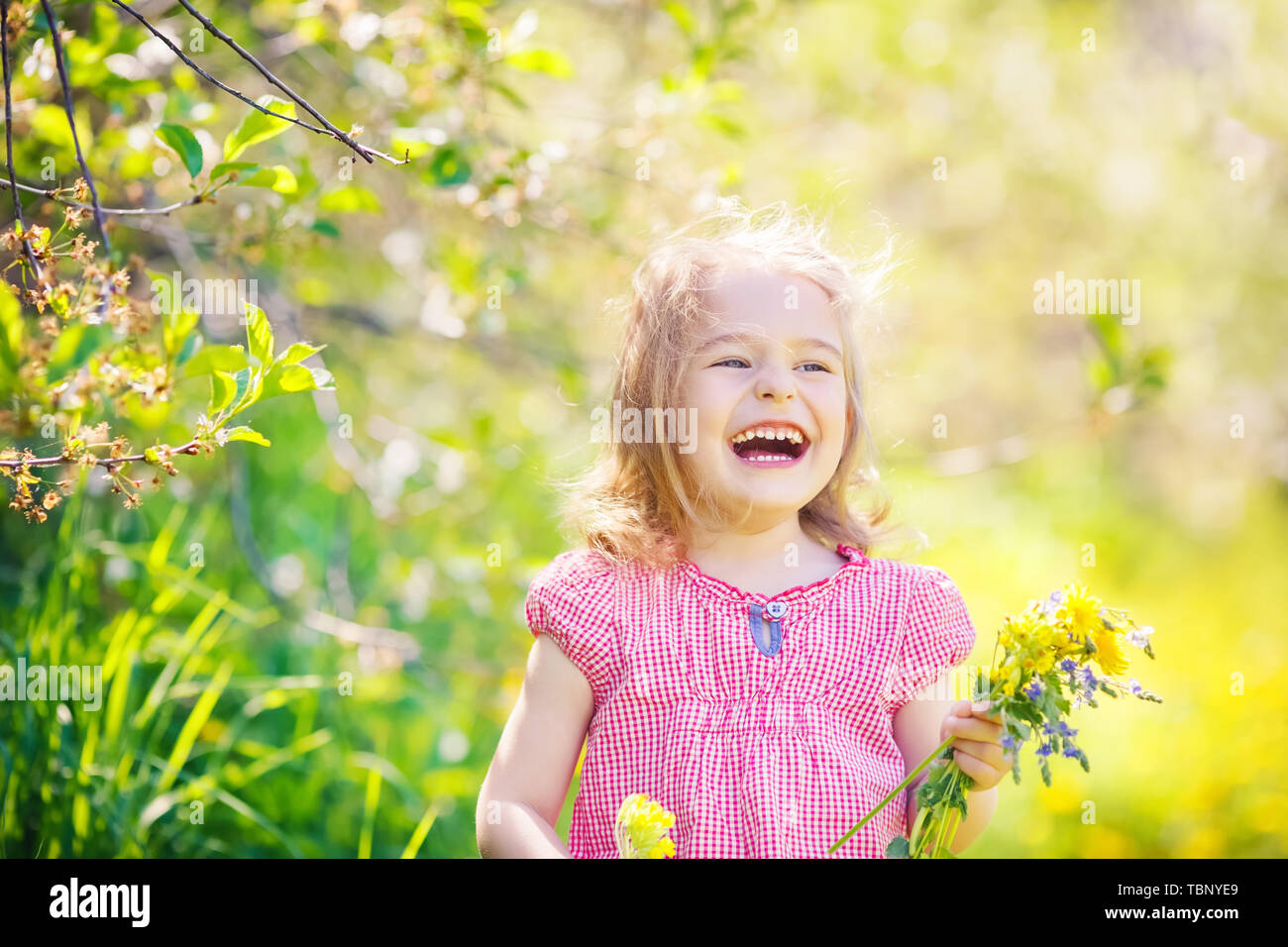 Happy little girl in spring sunny park Stock Photo - Alamy