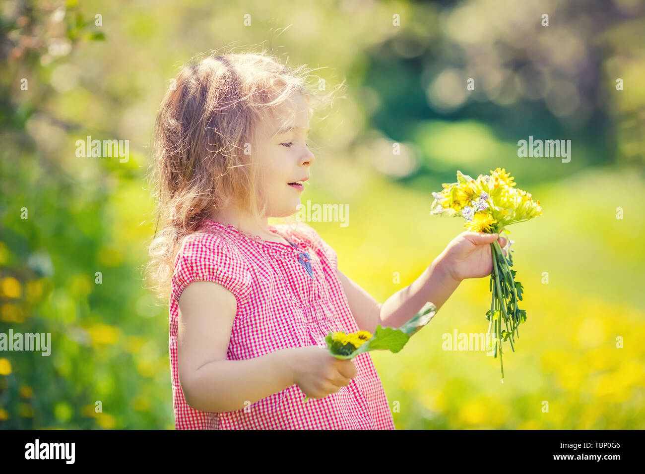 Happy little girl in spring sunny park Stock Photo - Alamy
