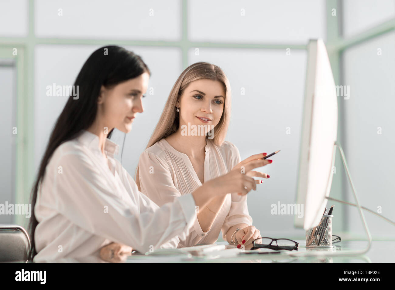 two employees are discussing something sitting at the office table ...