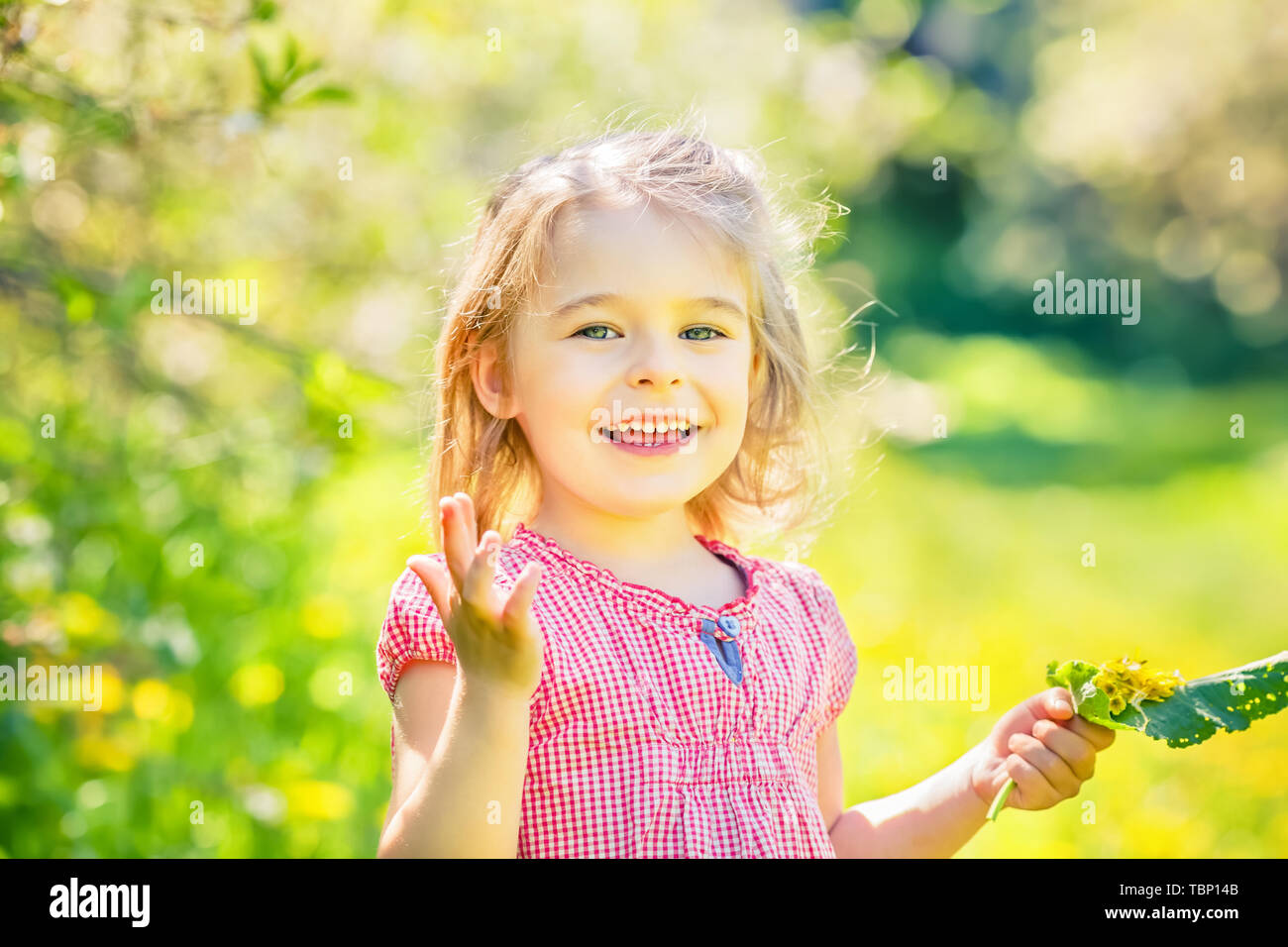 Happy little girl in spring sunny park Stock Photo - Alamy