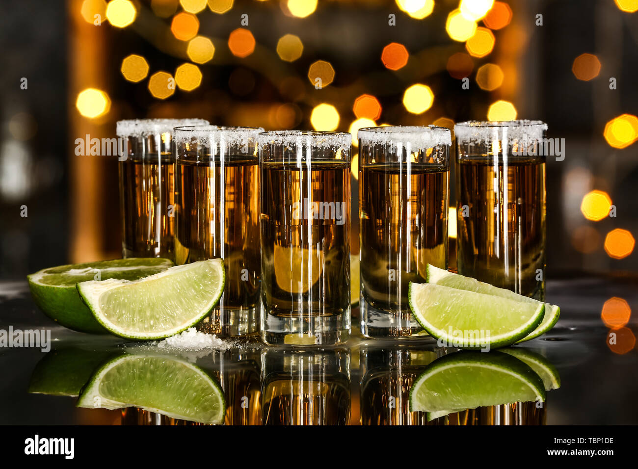 Shots of tequila on table against defocused lights Stock Photo - Alamy