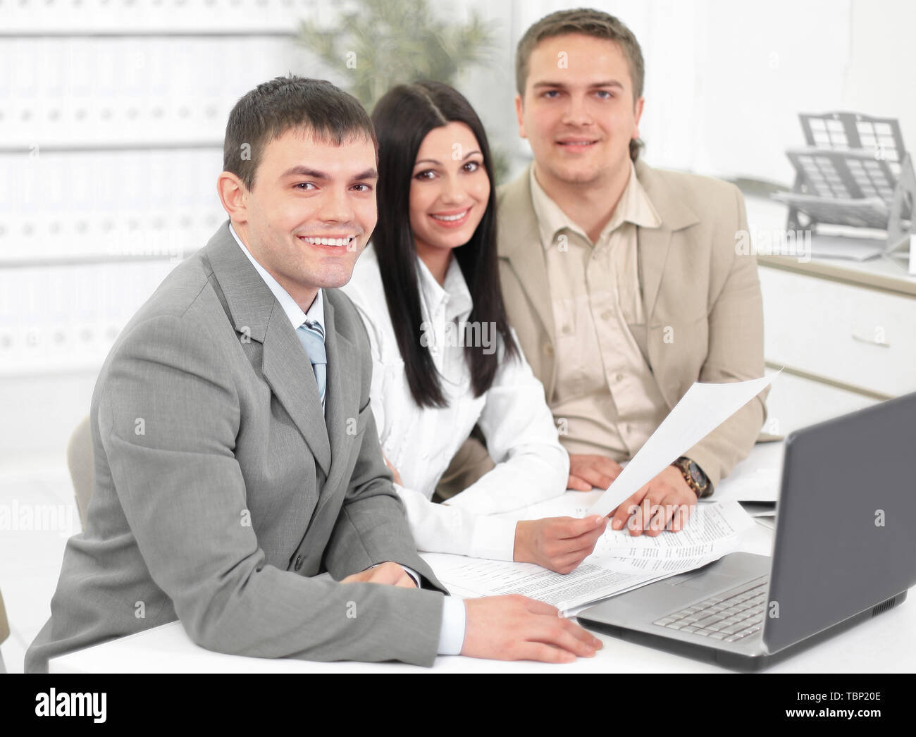 prospective employees discussing financial charts sitting at their Desk ...
