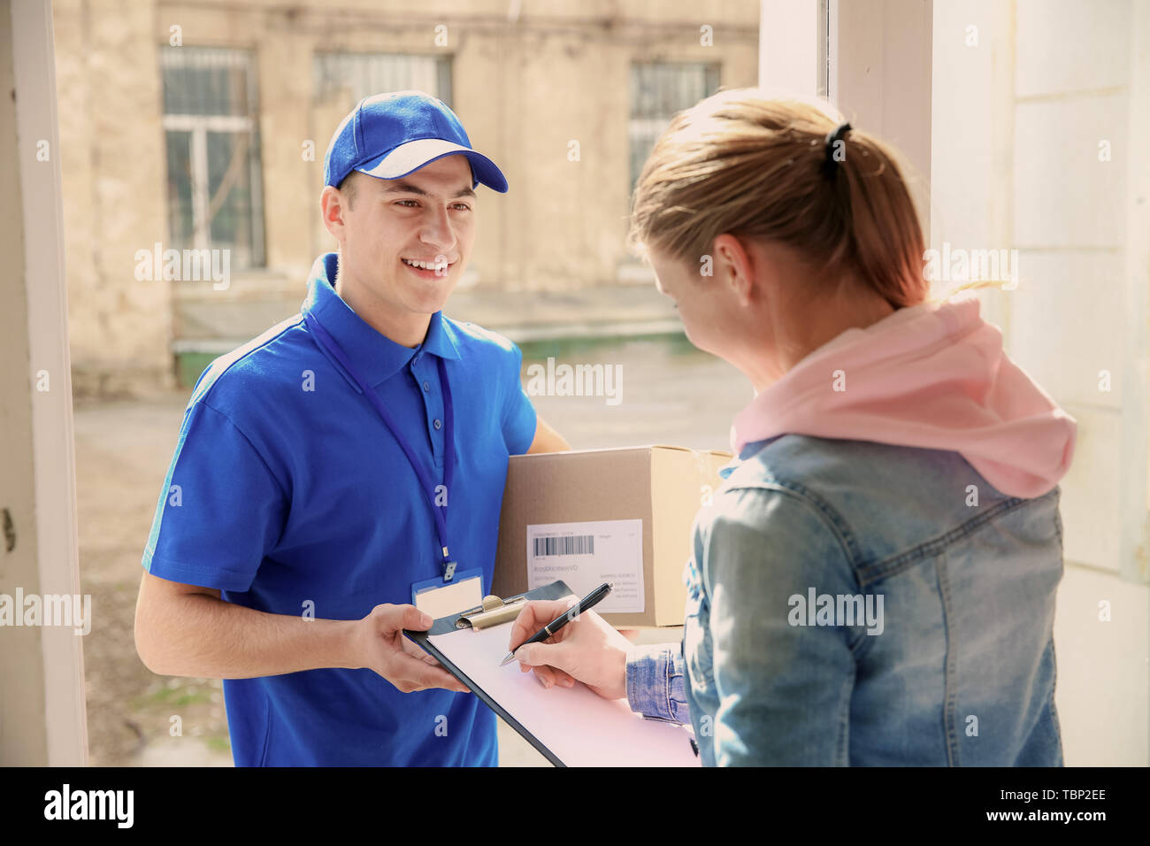 Woman signing documents to confirm receiving of order from delivery ...