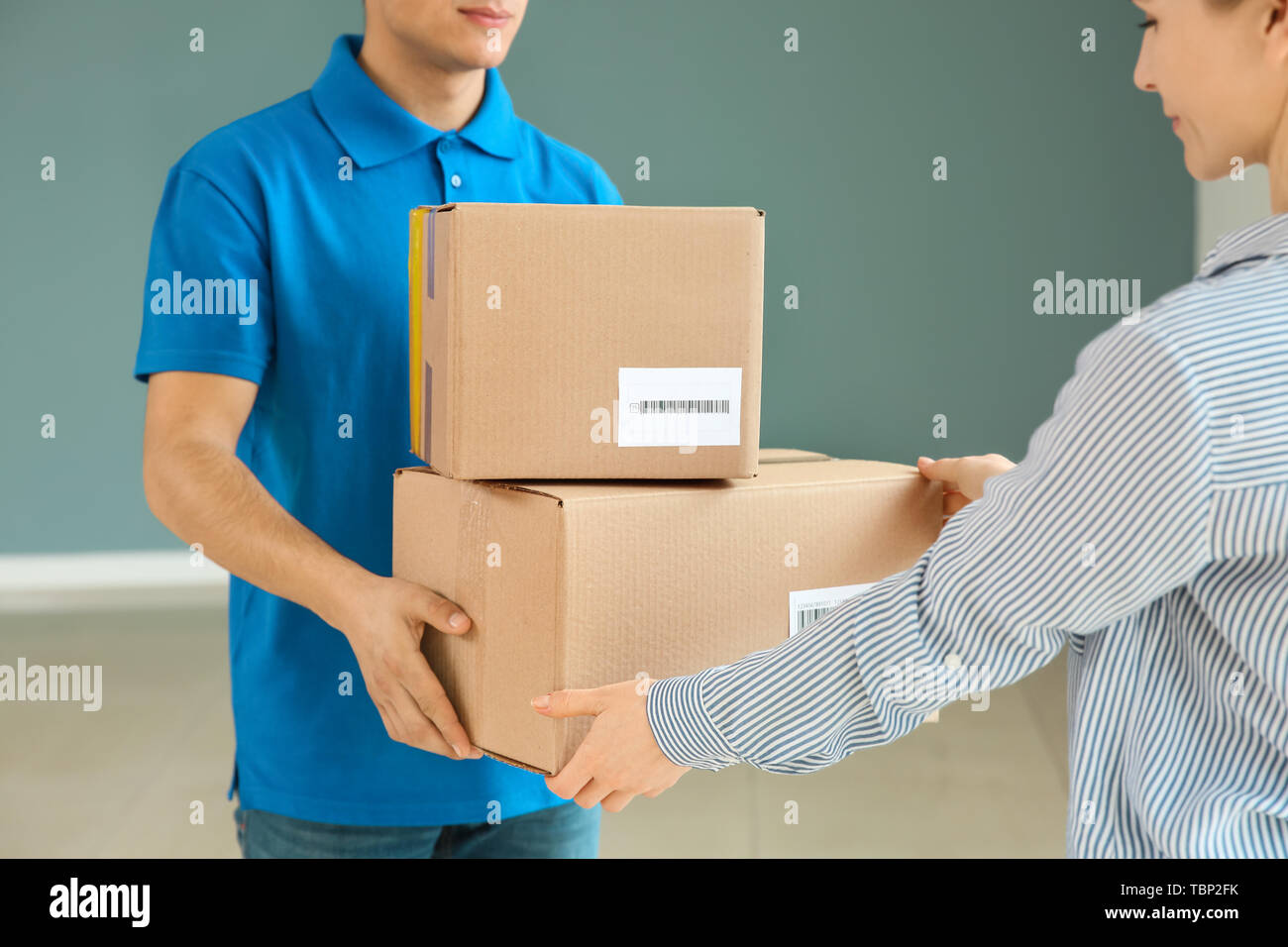 Woman receiving boxes from delivery man Stock Photo - Alamy