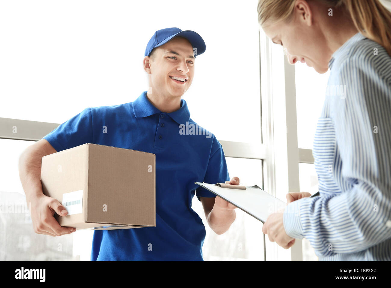 Woman signing documents to confirm receiving of order from delivery ...