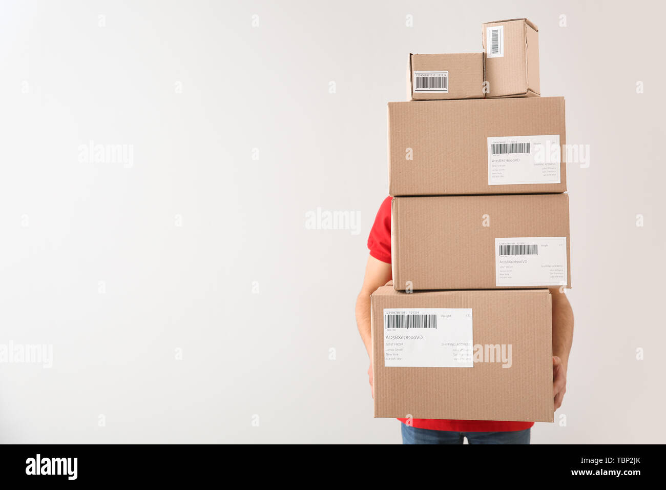 Delivery man with boxes on white background Stock Photo - Alamy