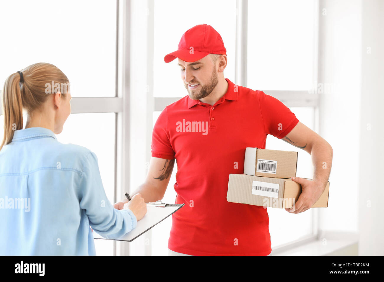 Woman signing documents to confirm receiving of order from delivery ...
