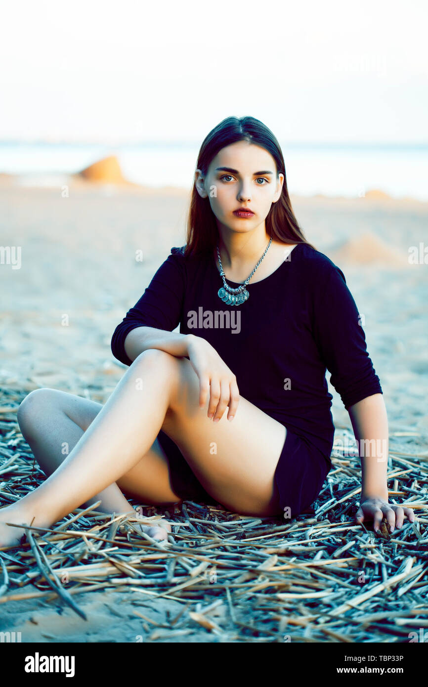 Young Pretty Brunette Girl With Long Hair Waiting Alone On Sand At