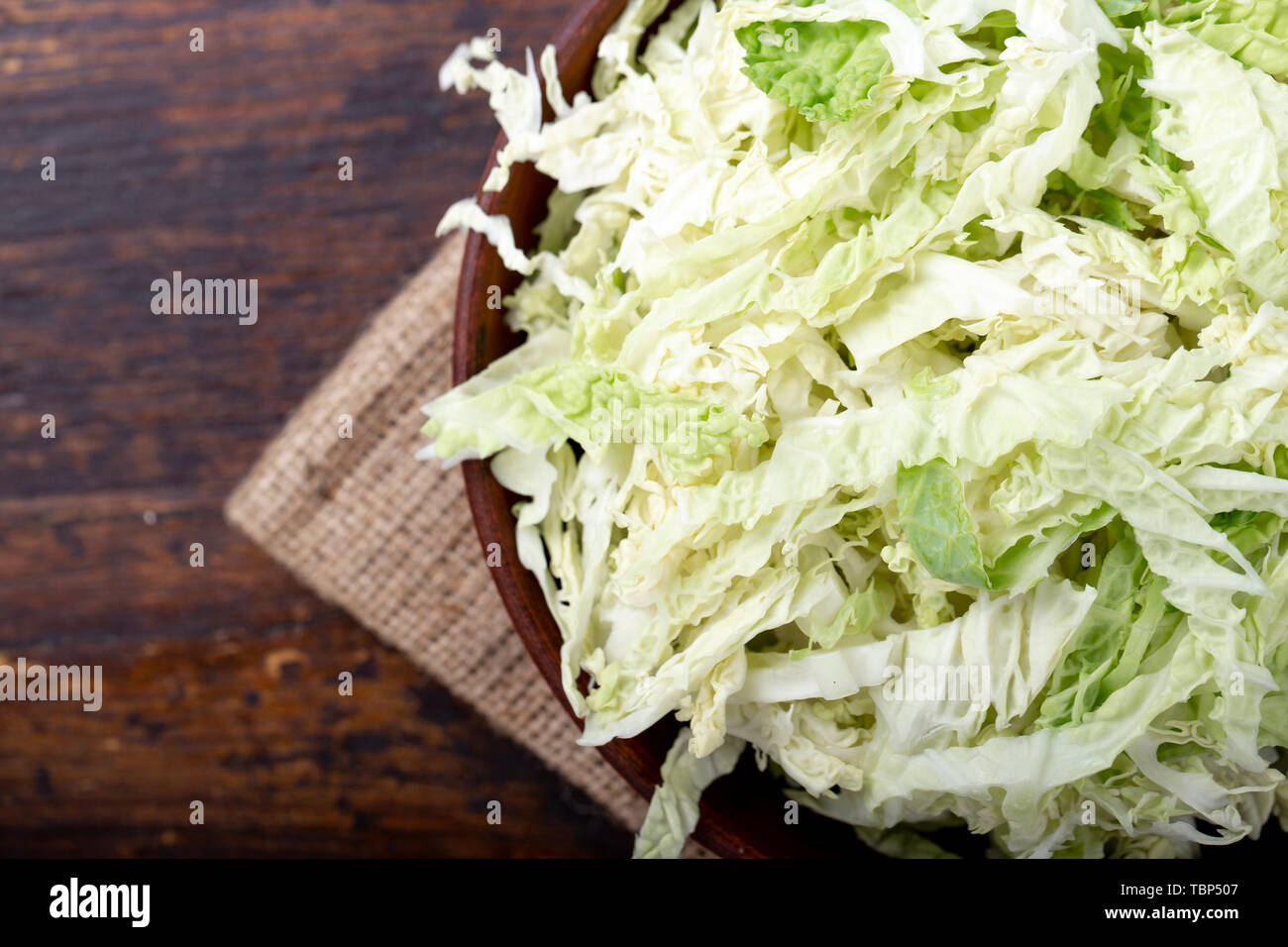 finely chopped savoy cabbage on table, on brown wooden background Stock ...
