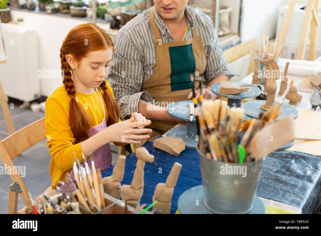 Pupil and teacher. Red-haired beautiful cute pupil and her art teacher ...