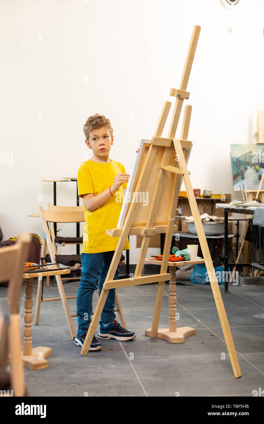 Talented little boy. Handsome talented little boy standing near drawing ...