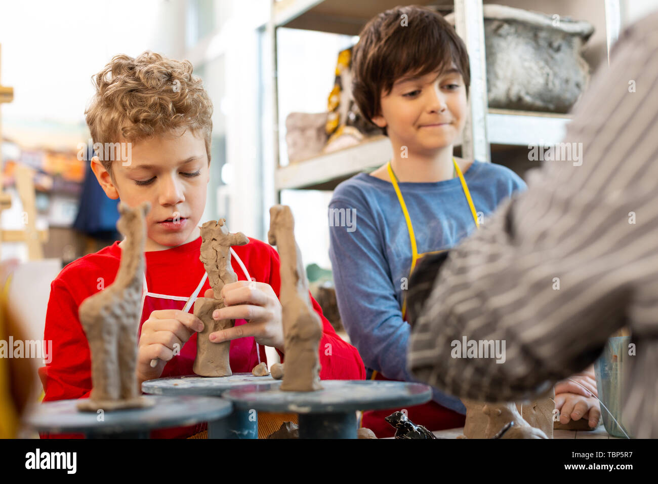 Two talented boys. Two talented boy modeling clay animals at the art ...