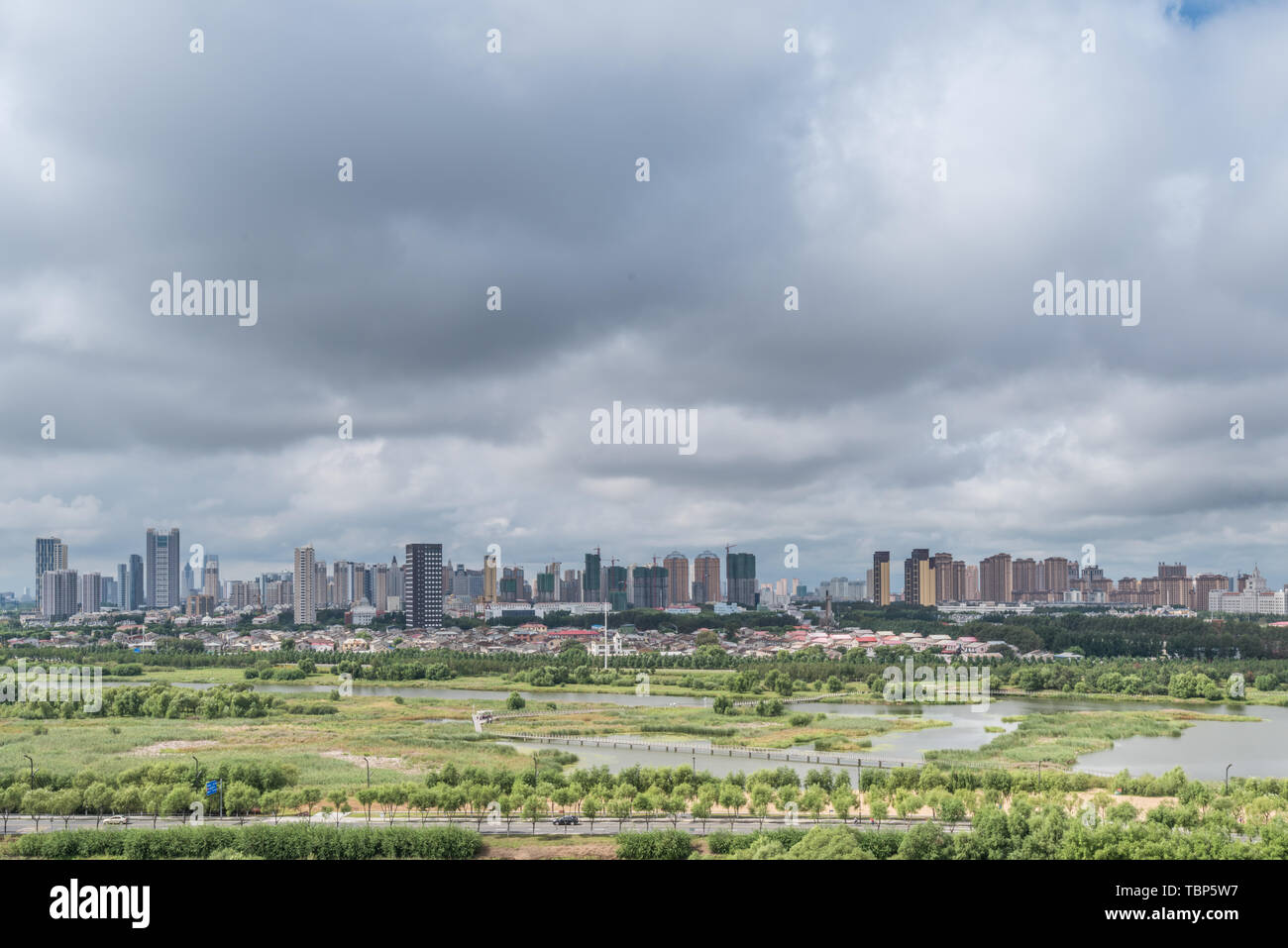 Cloudy weather overlooks riverside green space building Stock Photo - Alamy