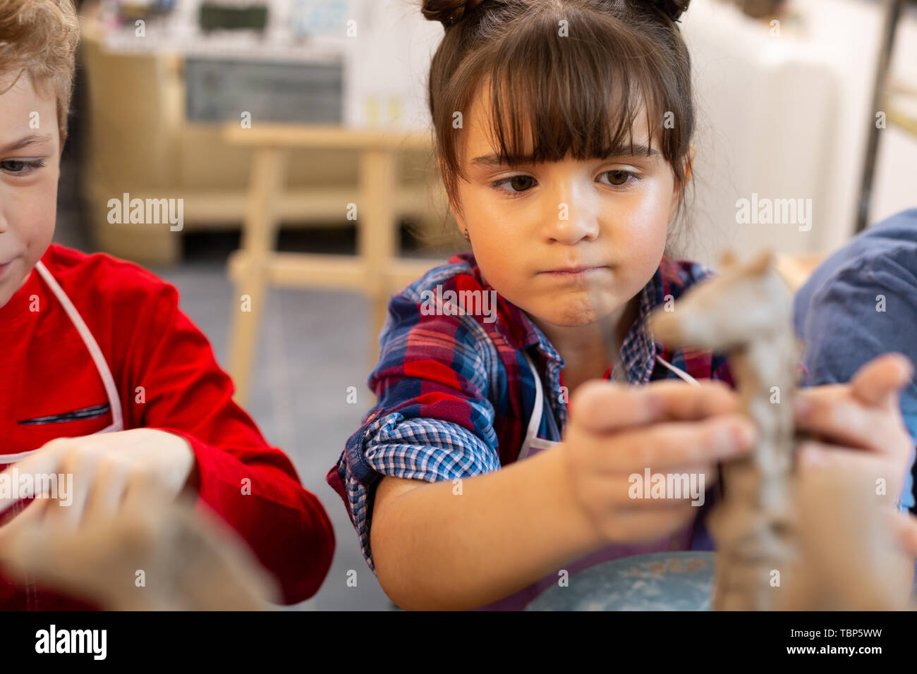 Funny cute girl. Funny cute girl feeling busy while modeling clay ...