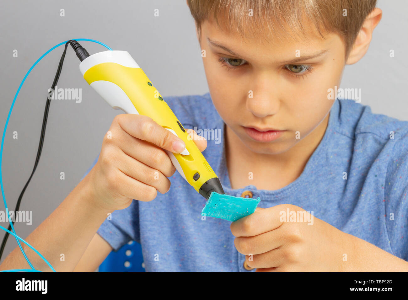 Boy creating with 3d printing pen new object Stock Photo - Alamy