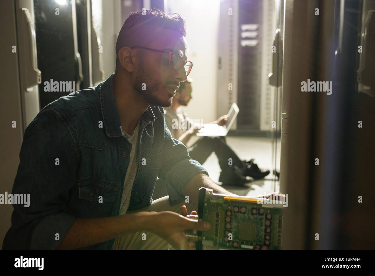 Serious busy repair engineer of database center inserting motherboard ...