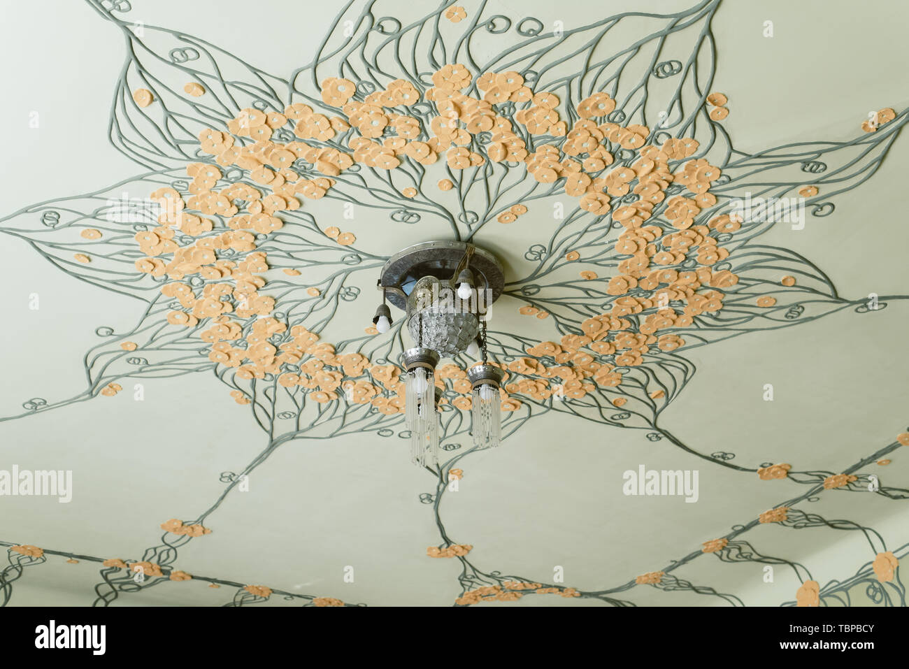 Yellow-green stucco in the chandelier on the ceiling. Gypsum flowers ...