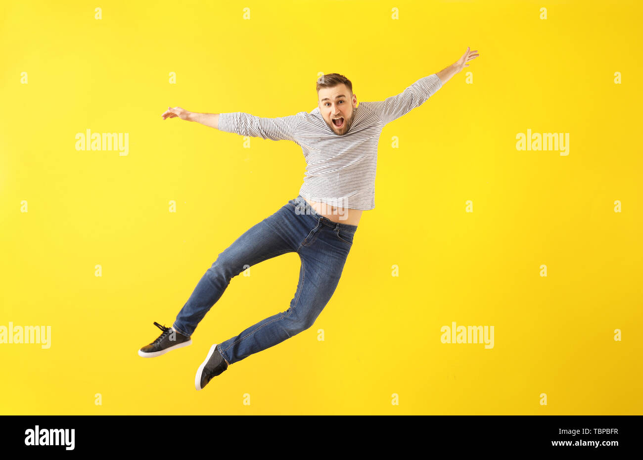 Surprised young man jumping hi-res stock photography and images - Alamy