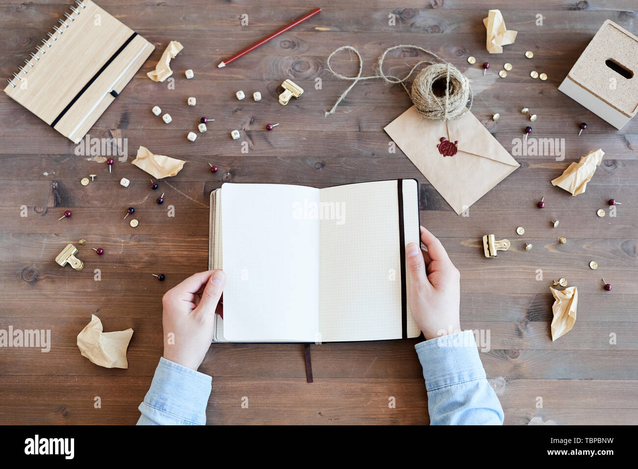 Directly above view of unrecognizable creative manager opening notepad ...