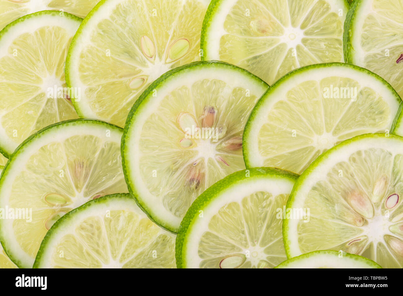 Green lemon slices on white background Stock Photo - Alamy