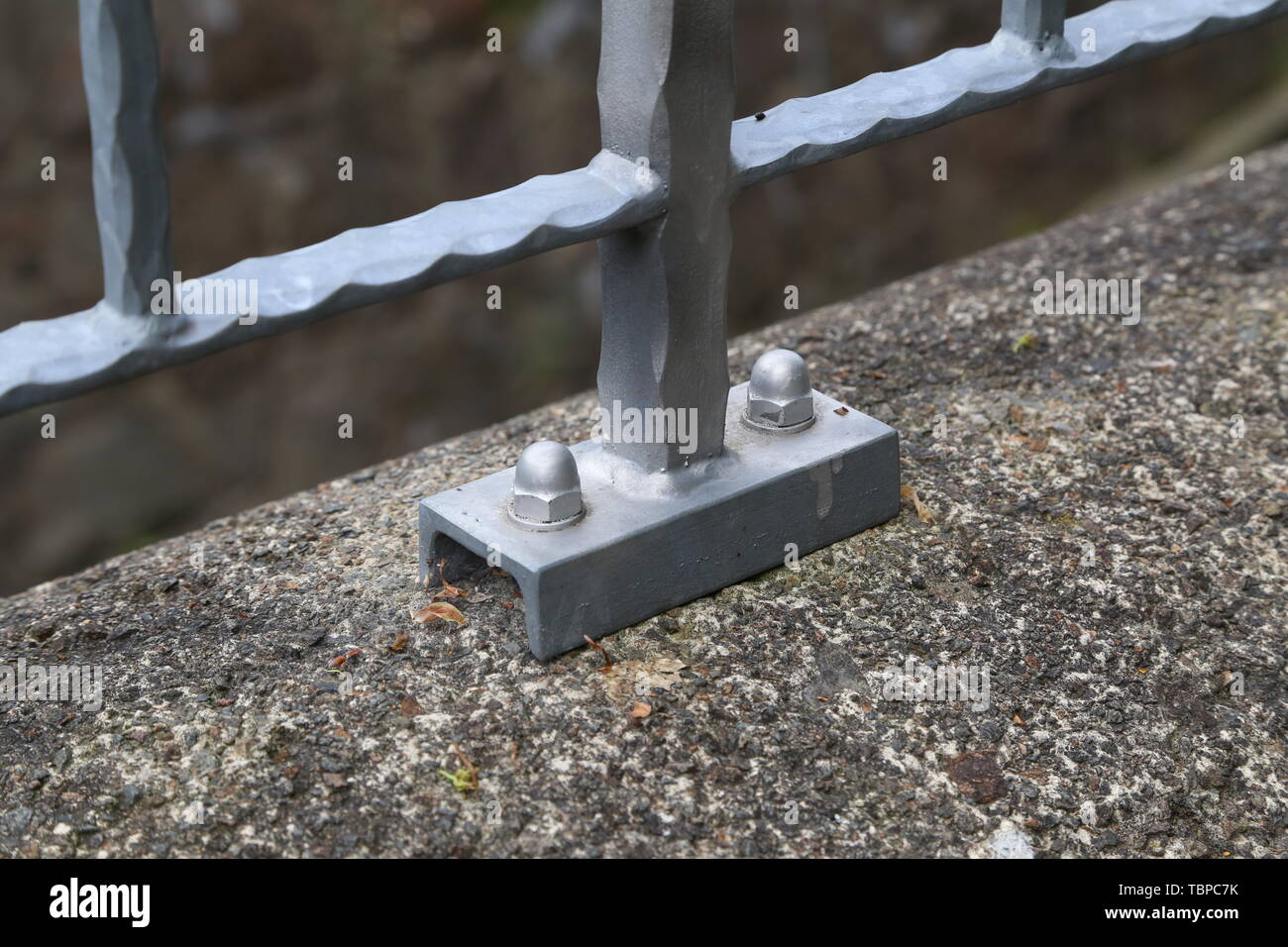 The metal fence is fixed on a concrete slab by means of bolts Stock ...