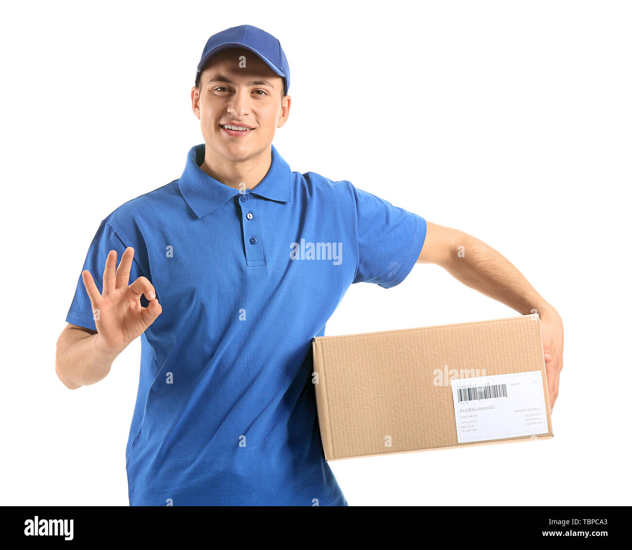 Delivery man with box showing OK on white background Stock Photo - Alamy