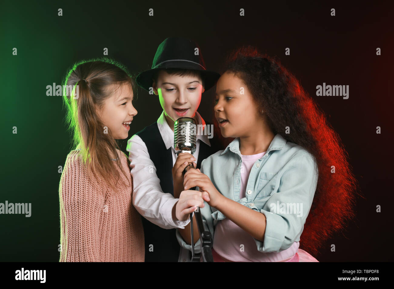 Little children singing in microphone on stage Stock Photo - Alamy