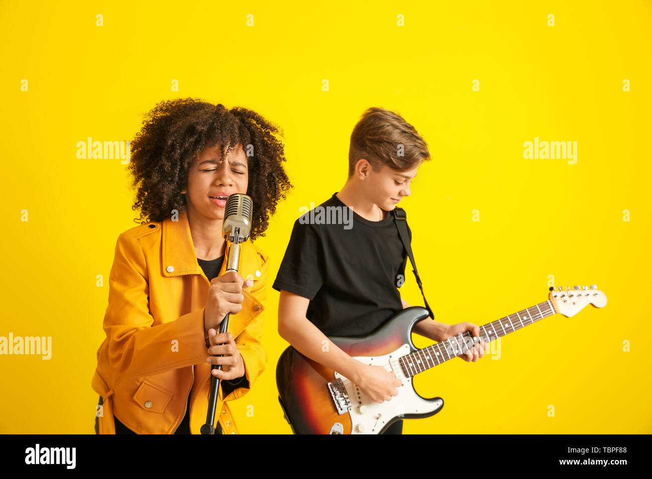Teenage musicians playing against color background Stock Photo - Alamy
