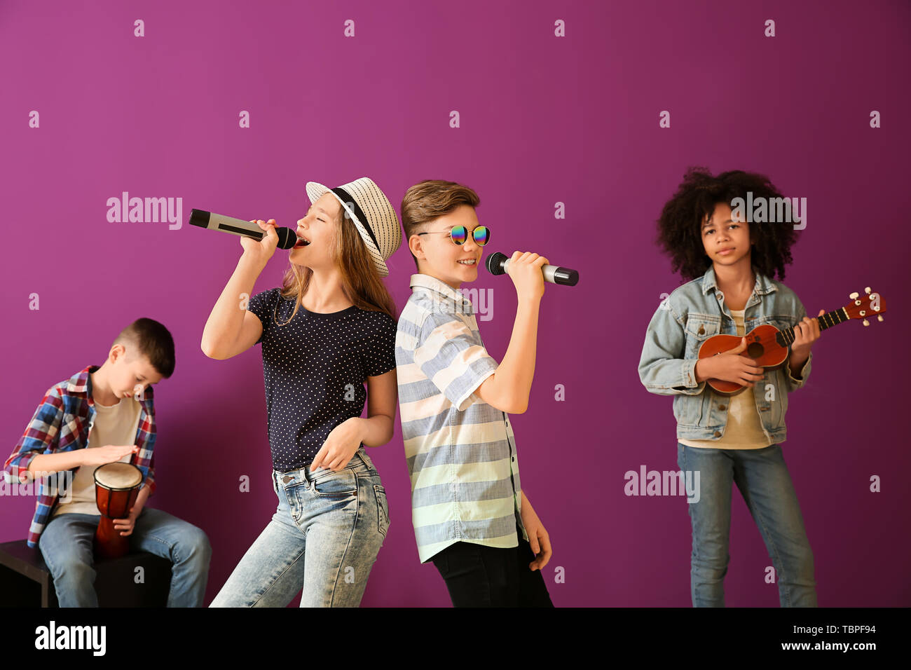 Teenage musicians playing against color background Stock Photo - Alamy
