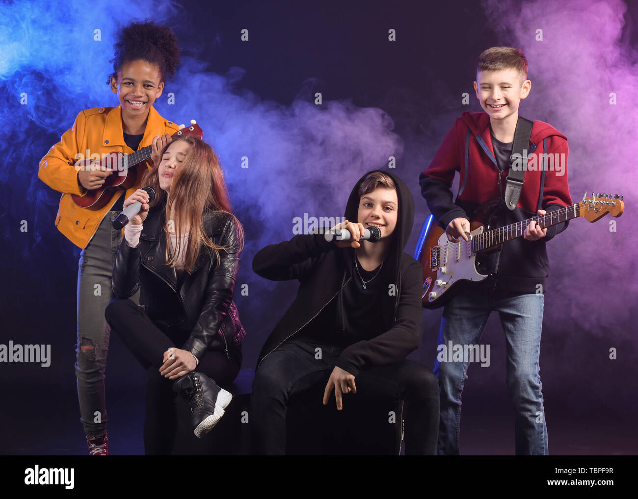 Band of teenage musicians on dark background Stock Photo - Alamy