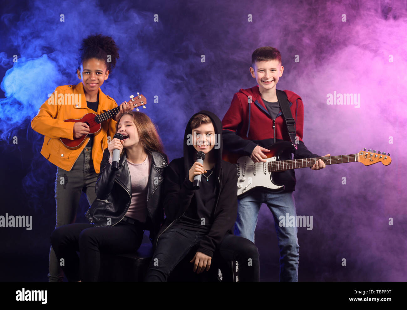 Band of teenage musicians on dark background Stock Photo - Alamy