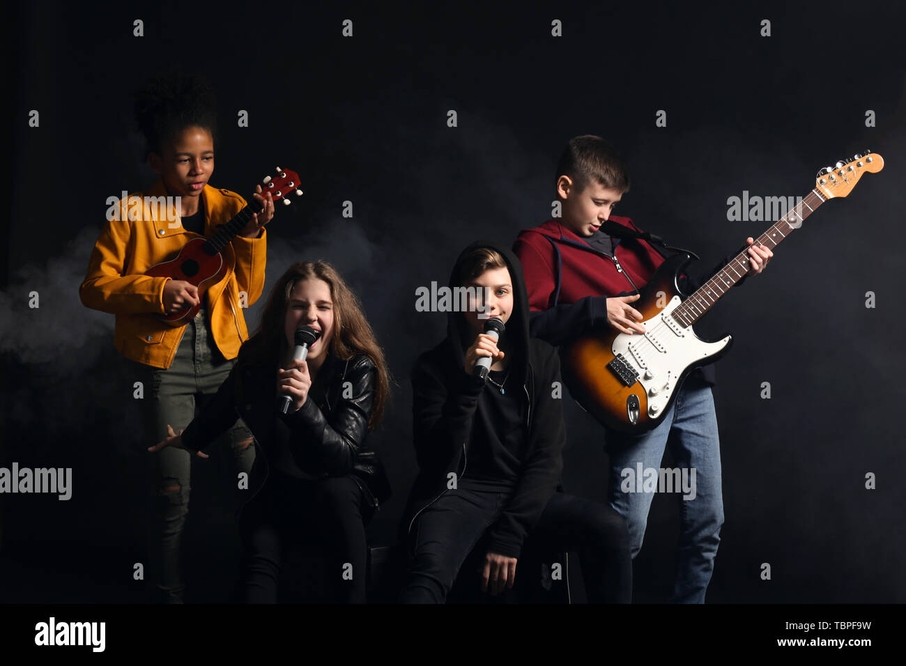 Band of teenage musicians on dark background Stock Photo - Alamy