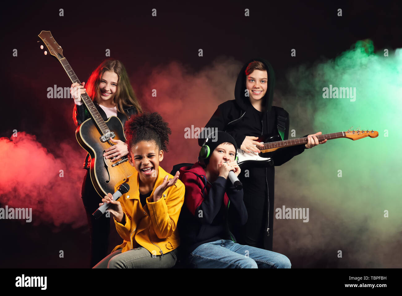 Band of teenage musicians on dark background Stock Photo - Alamy
