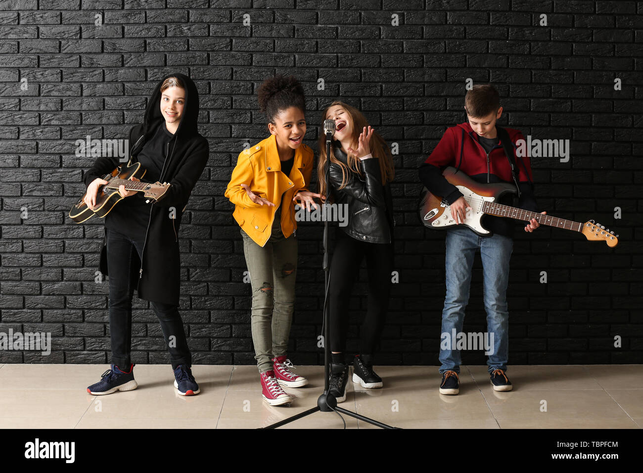 Band of teenage musicians playing against dark wall Stock Photo - Alamy