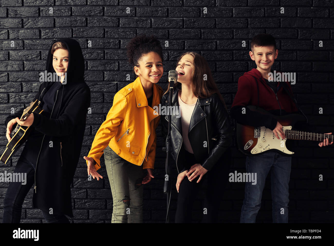 Band of teenage musicians playing against dark wall Stock Photo - Alamy