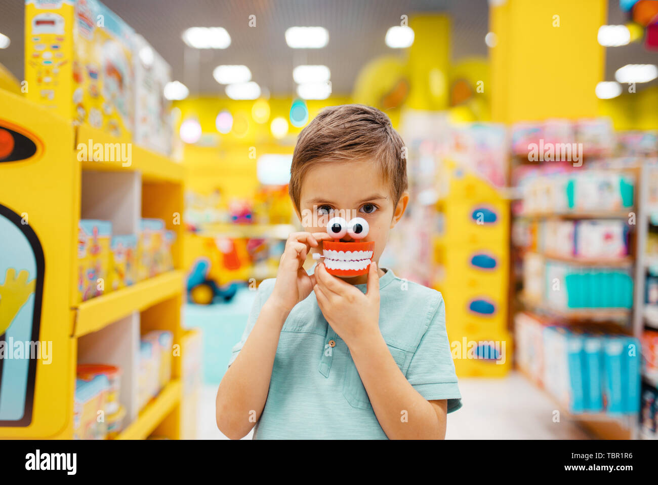 Boy holds jaw toy at the shelf in kids store Stock Photo - Alamy