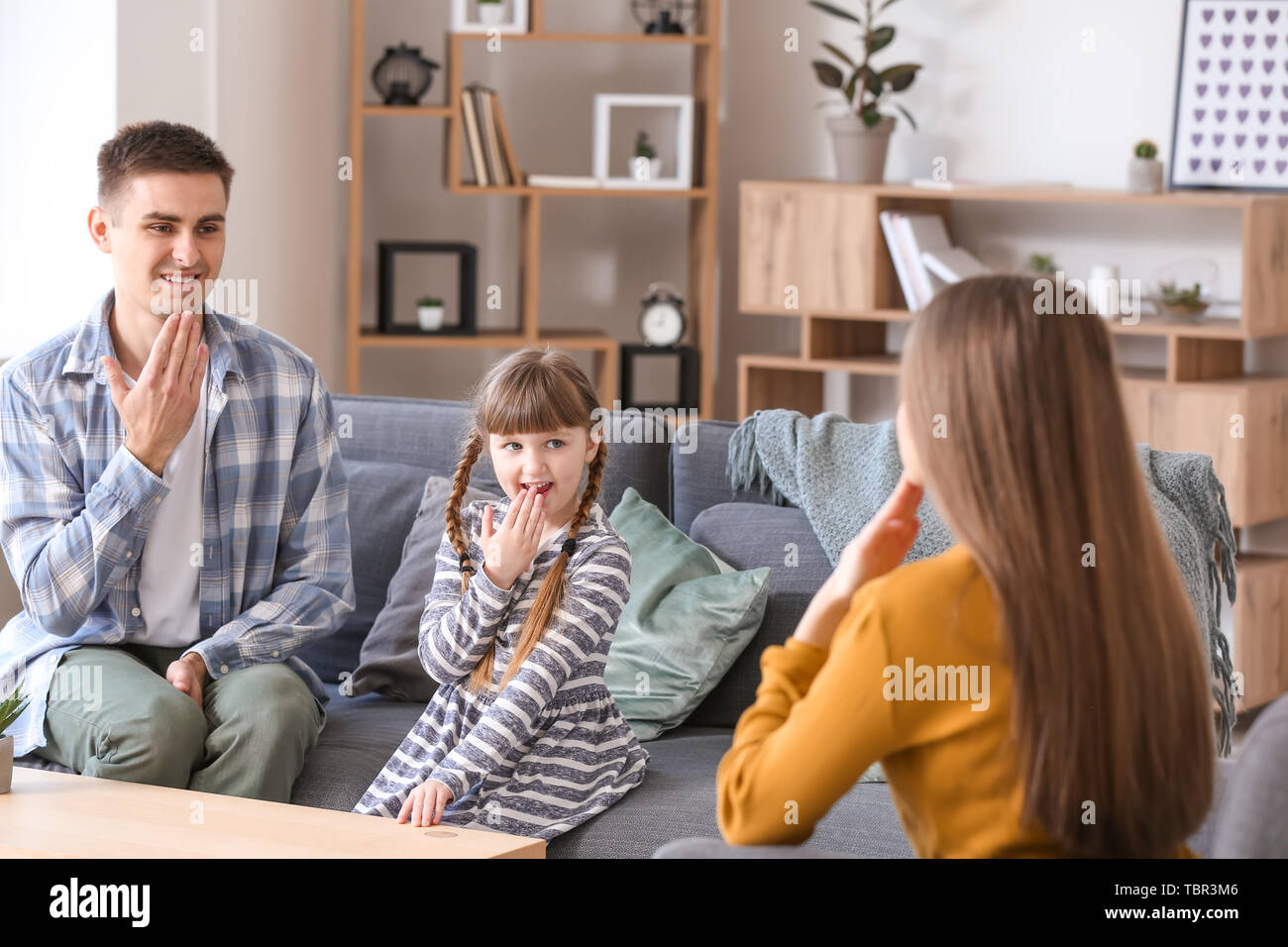 Deaf mute family using sign language at home Stock Photo - Alamy
