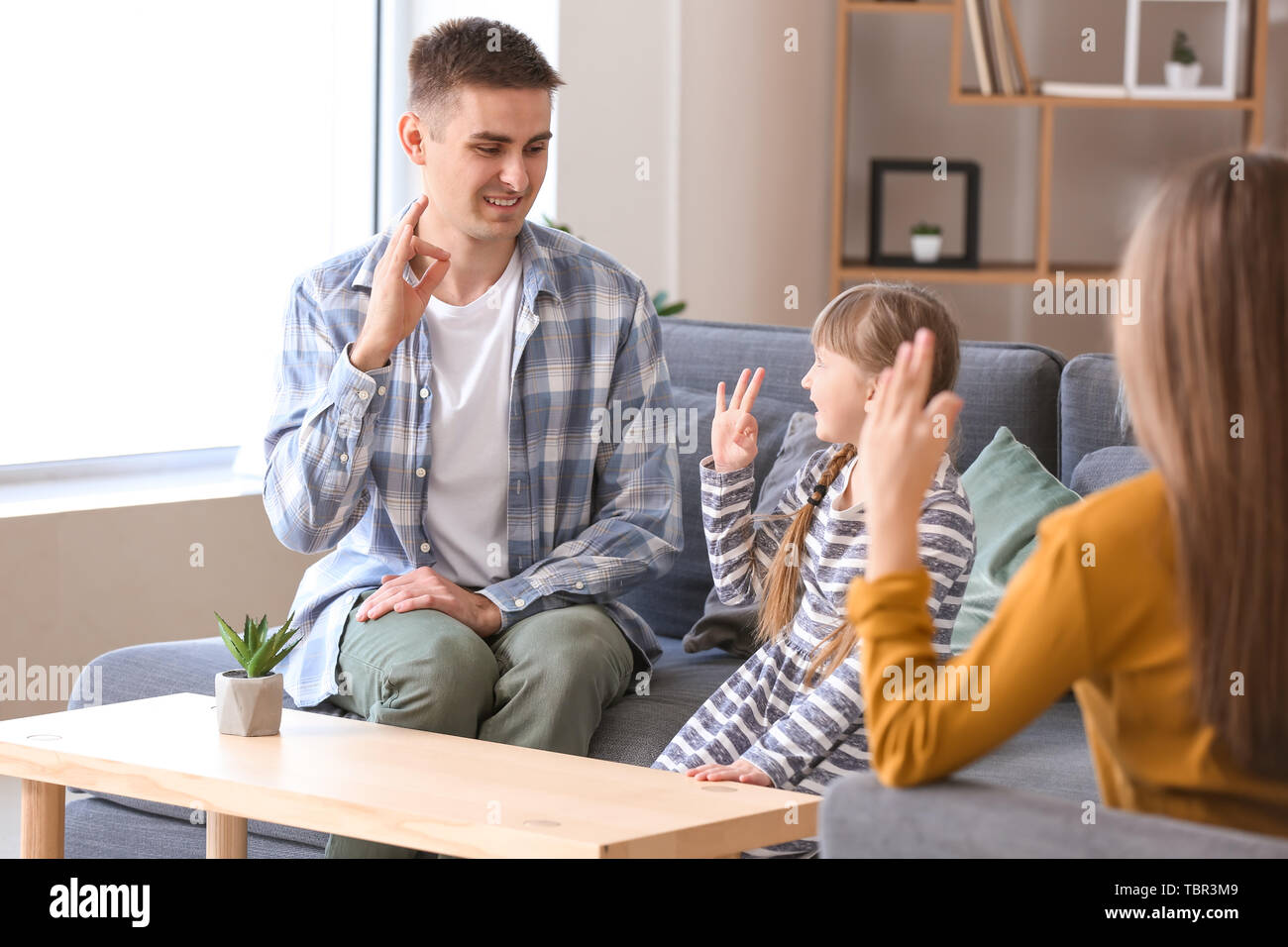 Deaf mute family using sign language at home Stock Photo - Alamy