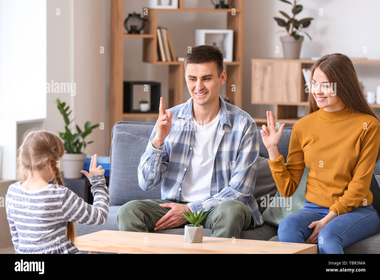 Deaf mute family using sign language at home Stock Photo - Alamy