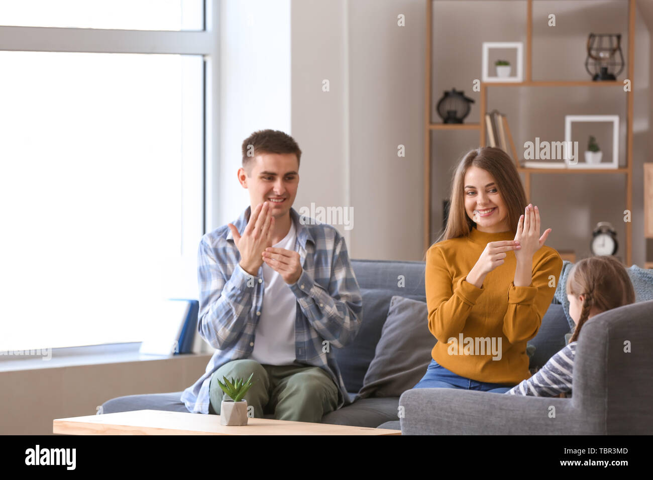 Deaf mute family using sign language at home Stock Photo - Alamy