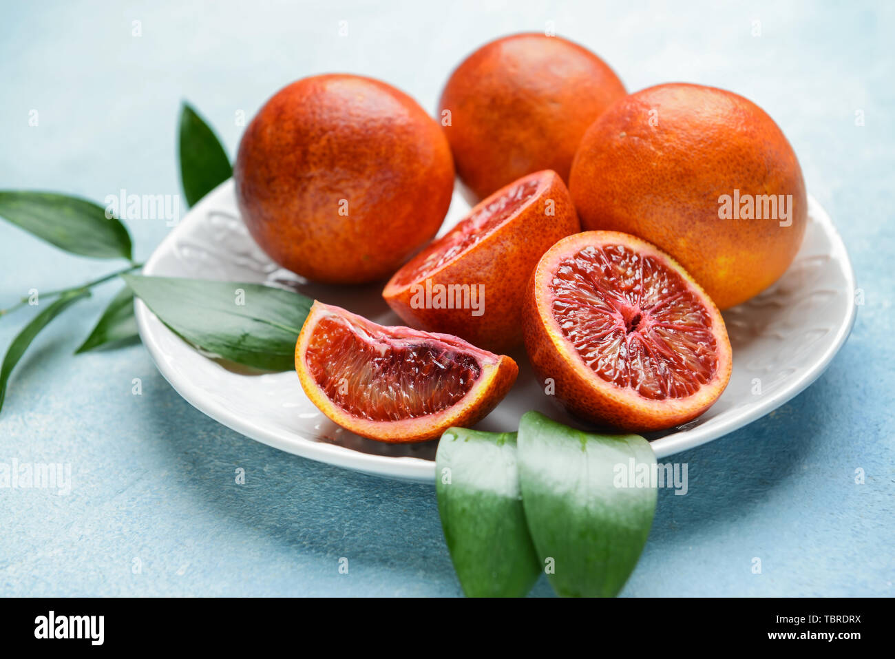 Plate with fresh blood oranges on color background Stock Photo - Alamy