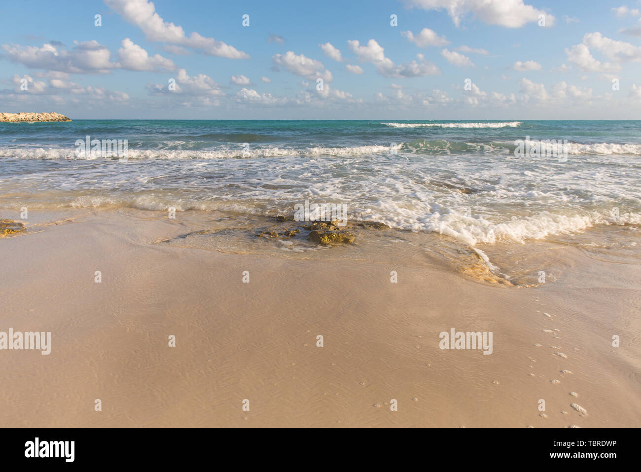 Granite rocks lay in sand on a Cancun beach at sunset, Mexico Stock ...