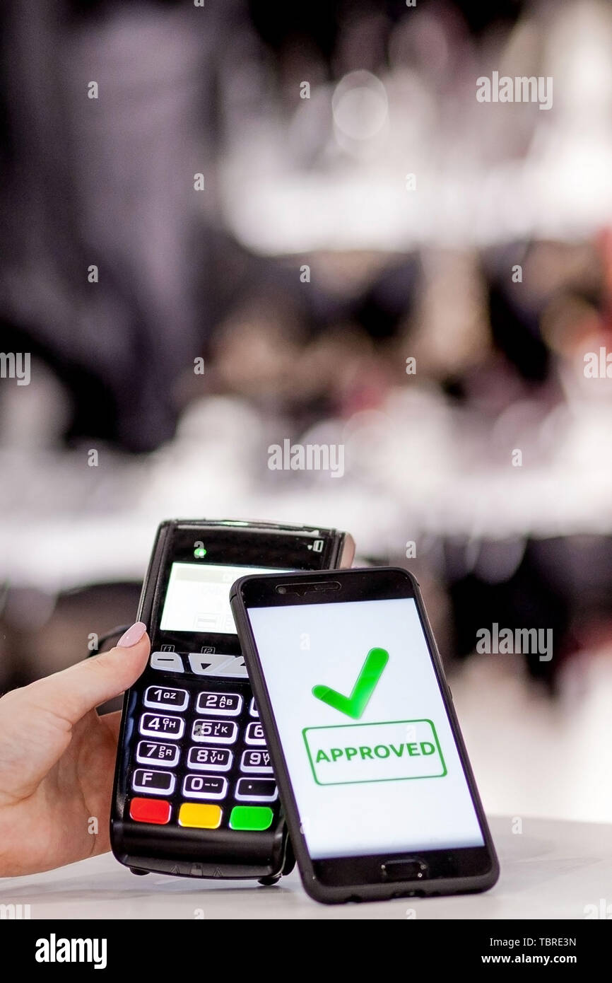 POS terminal, Payment Machine with mobile phone on store background ...