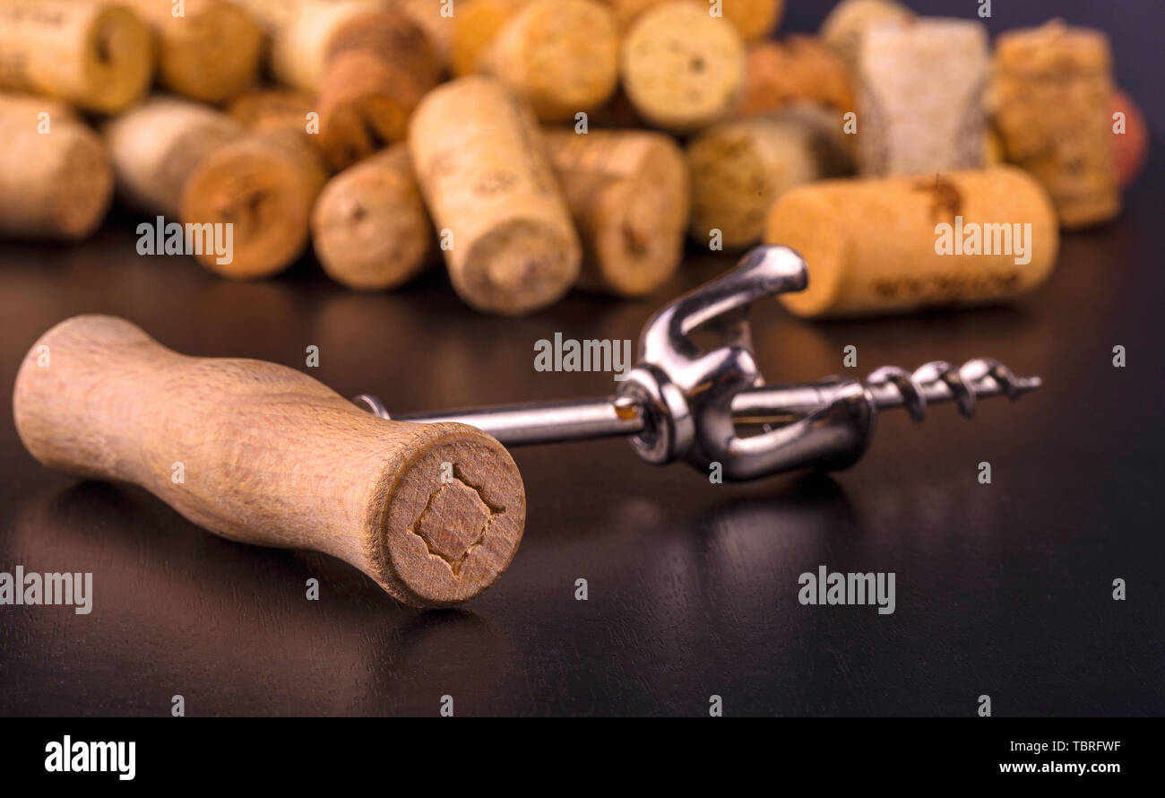 The wine corks and corkscrew on black wooden table Stock Photo - Alamy