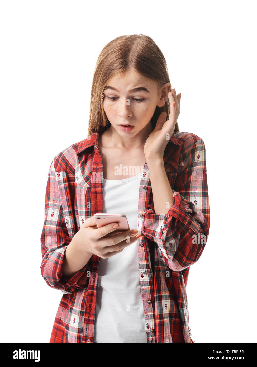 Shocked teenage girl with mobile phone on white background Stock Photo ...