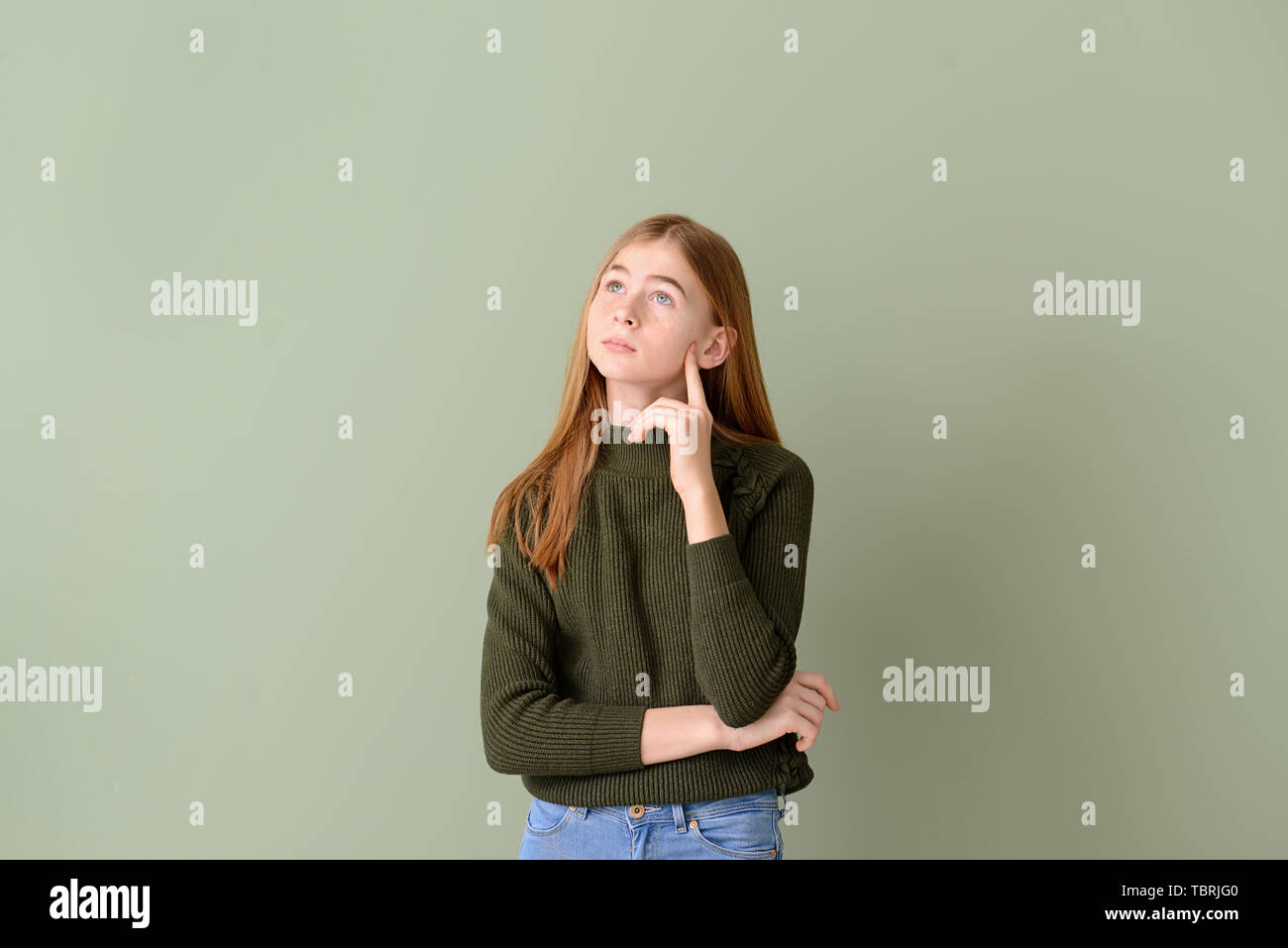 Thoughtful teenage girl on color background Stock Photo - Alamy