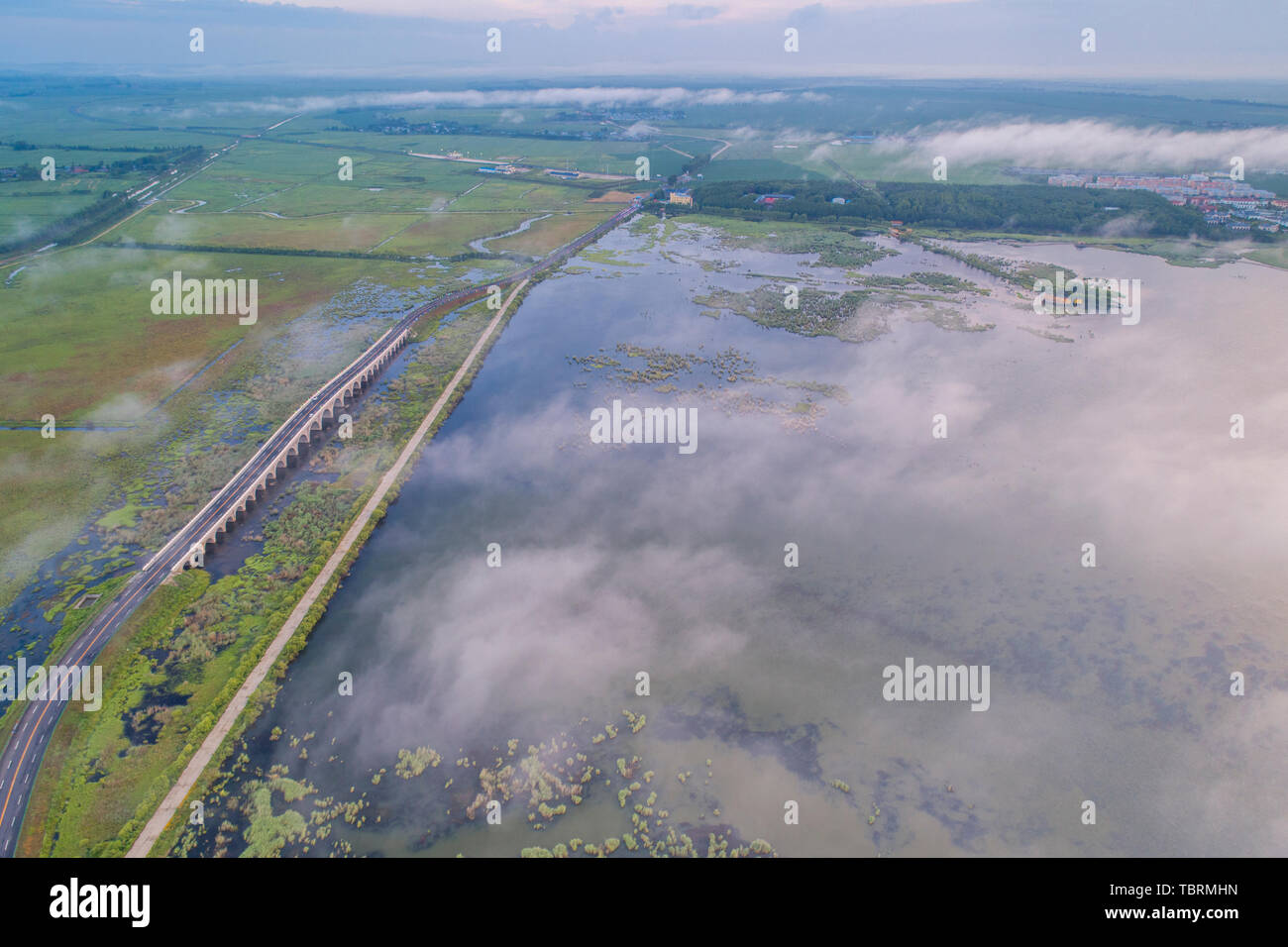 July summer Xingkai Lake clouds rise in the morning light reflects the ...